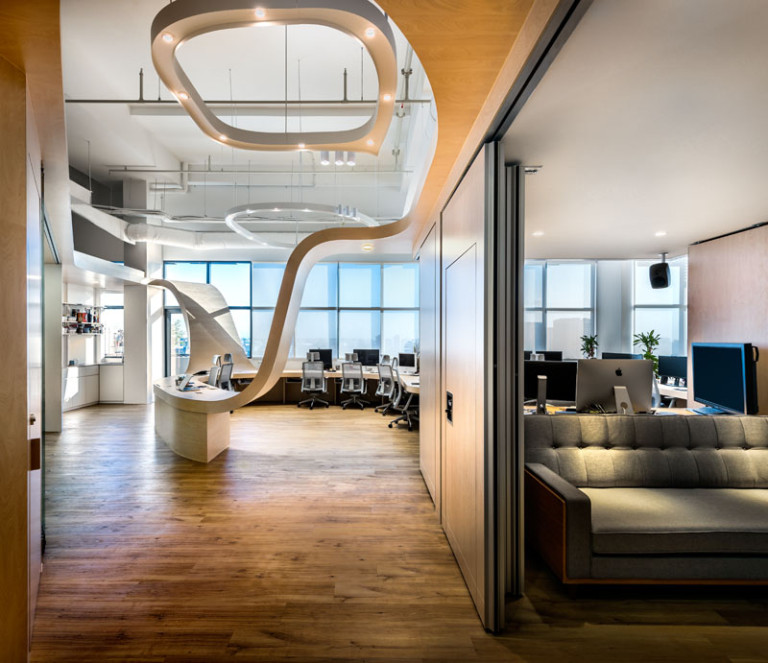 A ribbon-like wood table winds its way throughout this office, and the ...