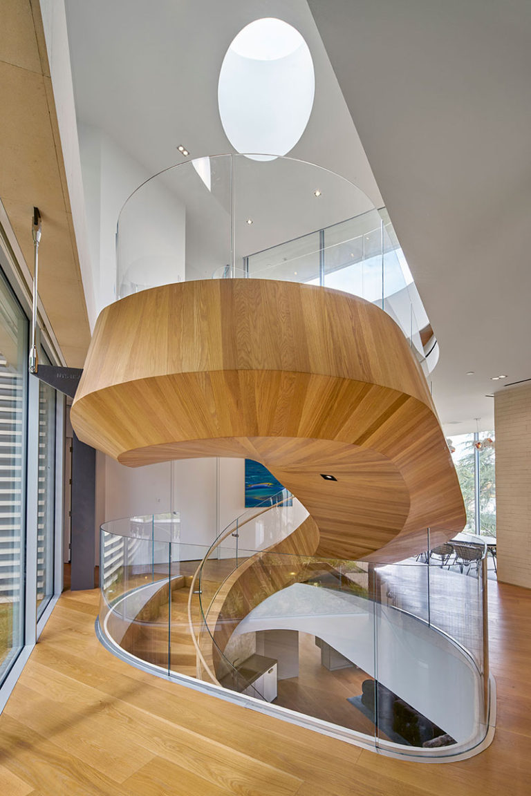 A sculptural wood spiral staircase welcomes visitors to this house in ...