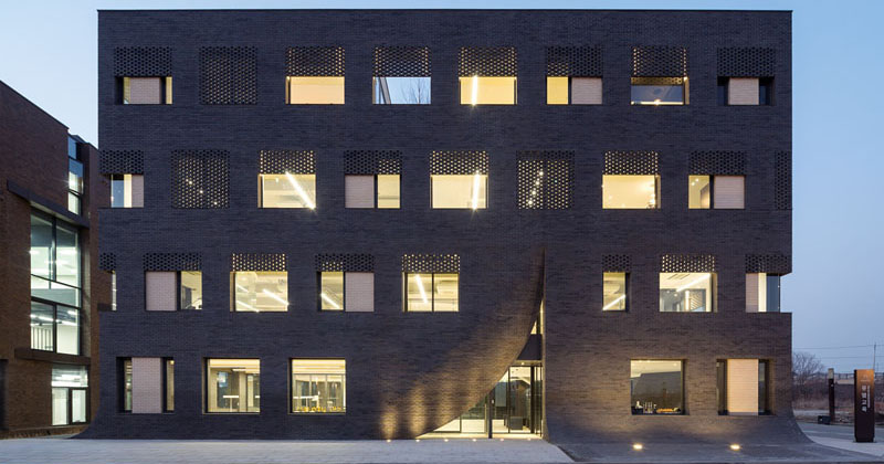 The entrances to this brick building are pulled away like a curtain