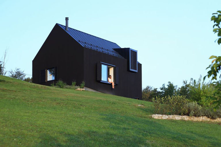 This small black house sits on a slope in the Croatian countryside