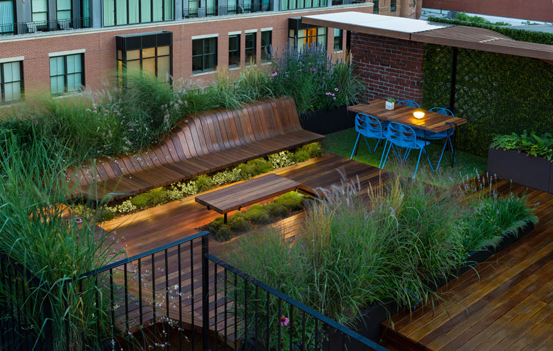 This Rooftop Deck Has Custom Designed Wood Benches Surrounded By Greenery