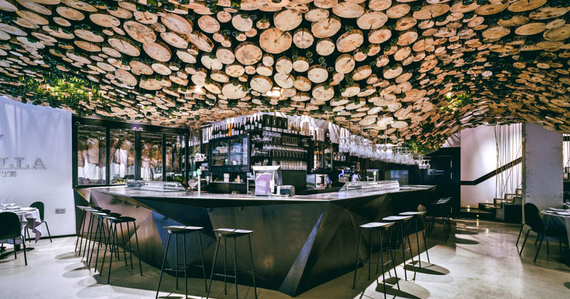 A Wavy Installation Of Cut Logs And Green Glass Cover The Ceiling Of ...