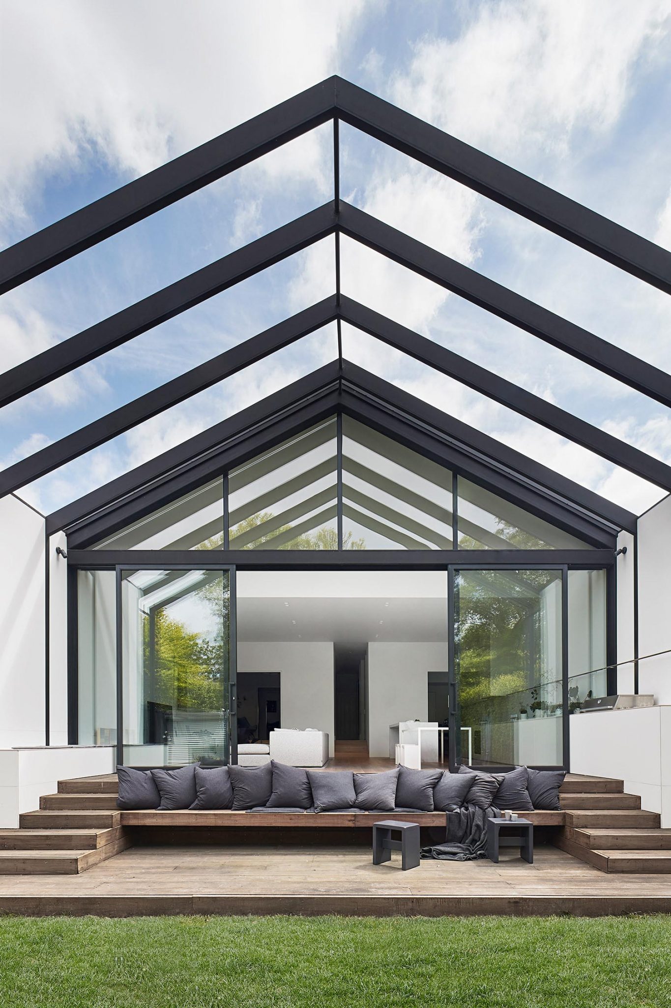 A Wall Of Windows With Sliding Glass Doors Connect The Interior Of This ...