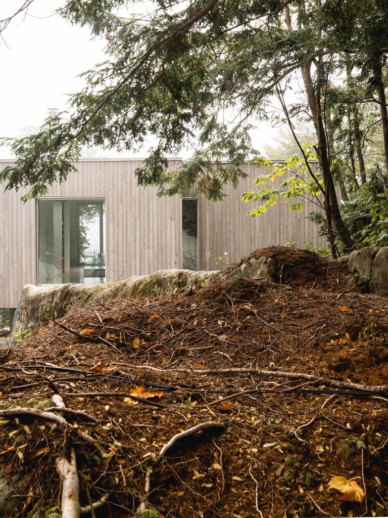 A House In The Forest Clad In Eastern Cedar Siding Is Raised Above The ...