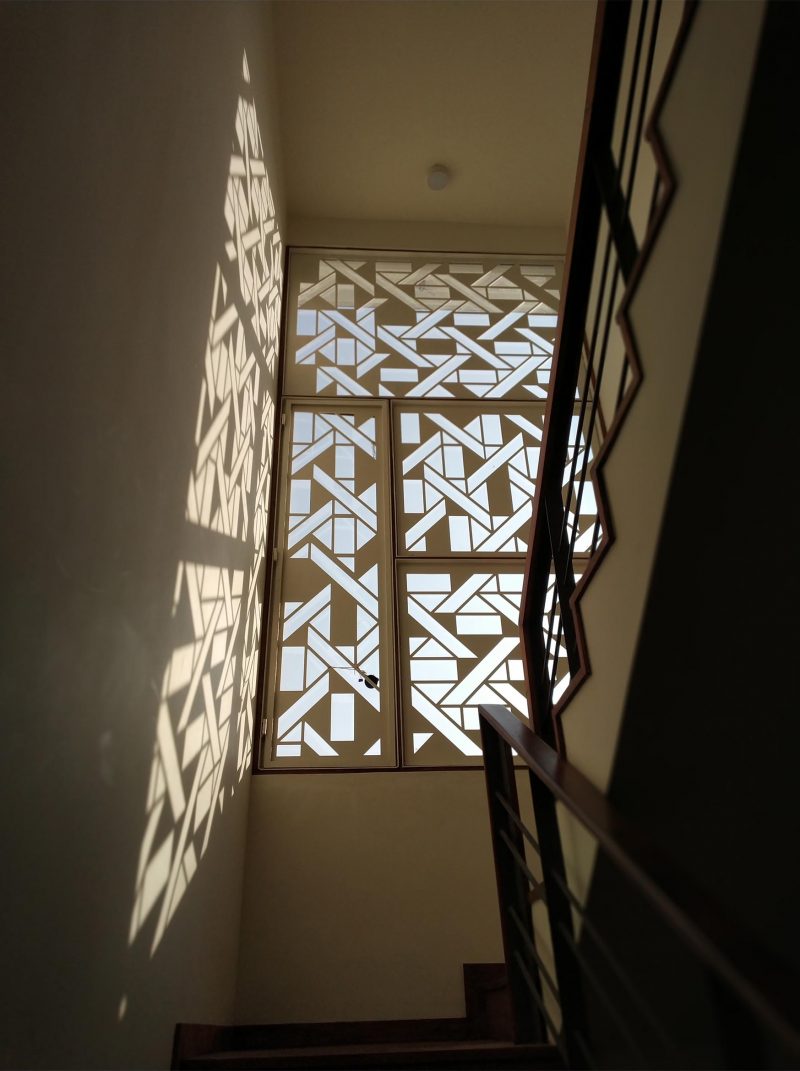 A Screen Made From Wood Blocks Wraps Around The Corner Of This Home
