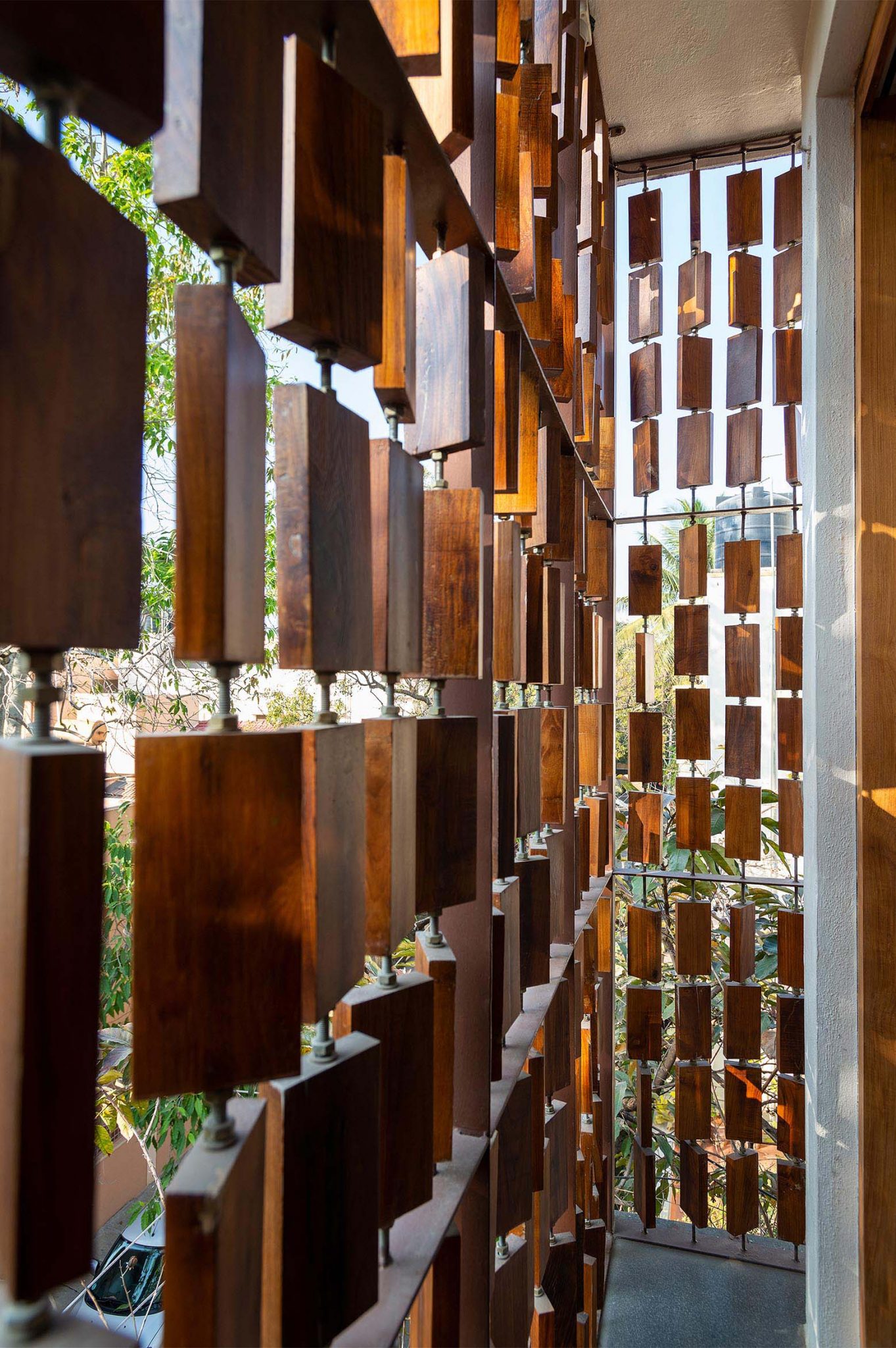 A Screen Made From Wood Blocks Wraps Around The Corner Of This Home