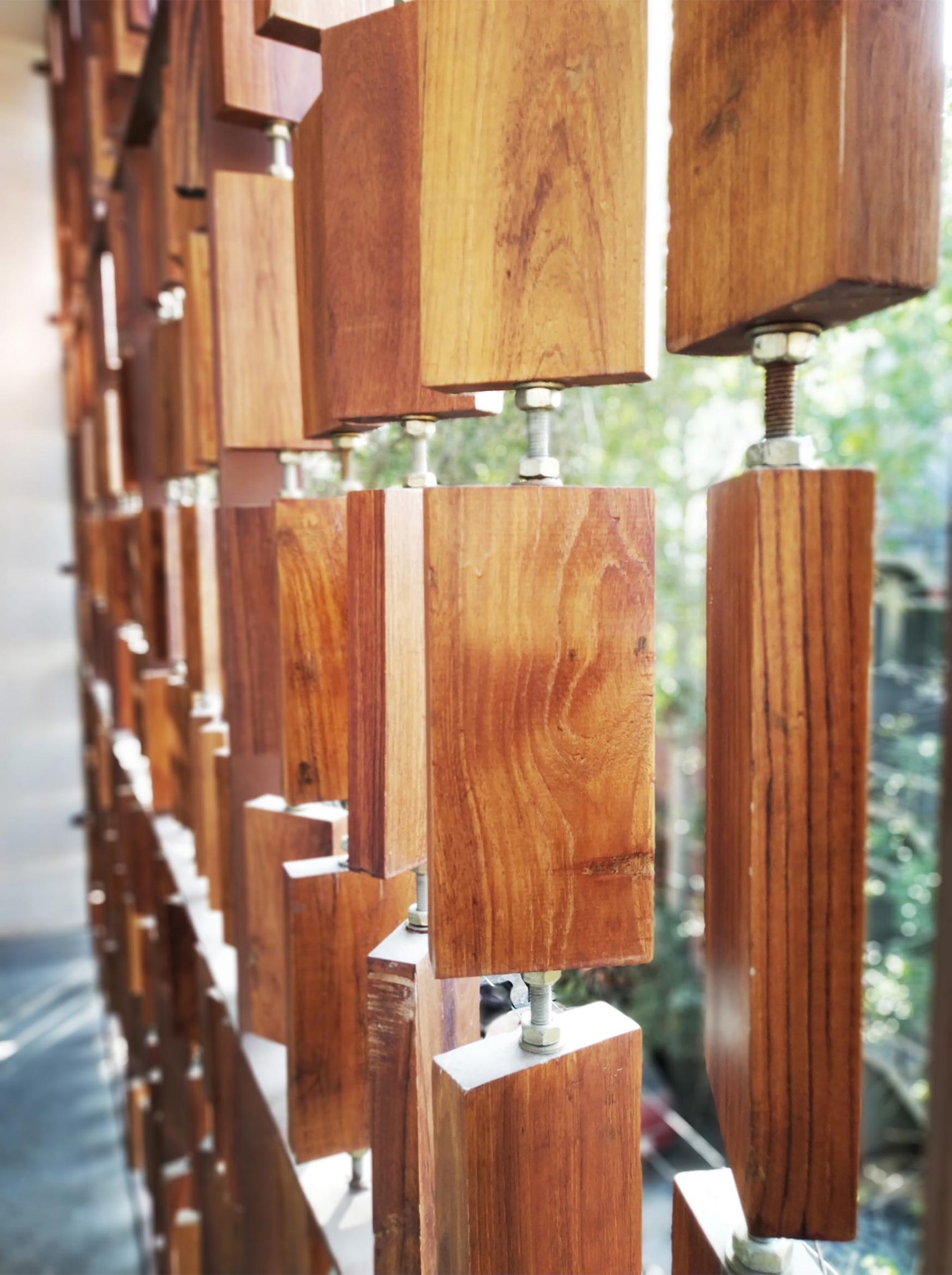 A Screen Made From Wood Blocks Wraps Around The Corner Of This Home