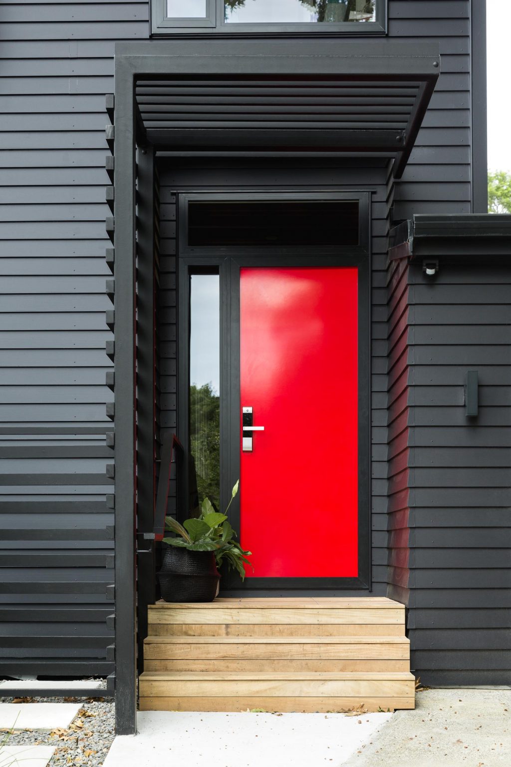 The Black Exterior Of This Home With A Bold Red Front Door Hides A ...