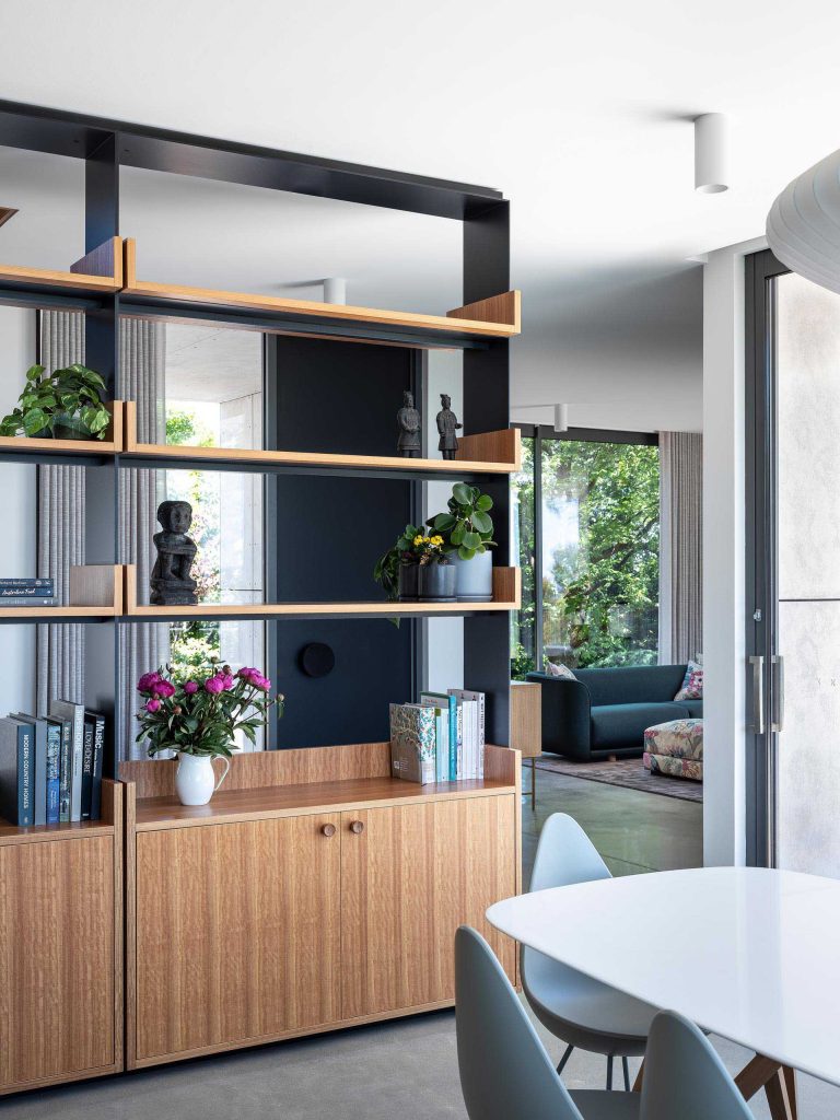 An Open Shelving Unit Is Used As A Partition To Create A Hallway Inside ...