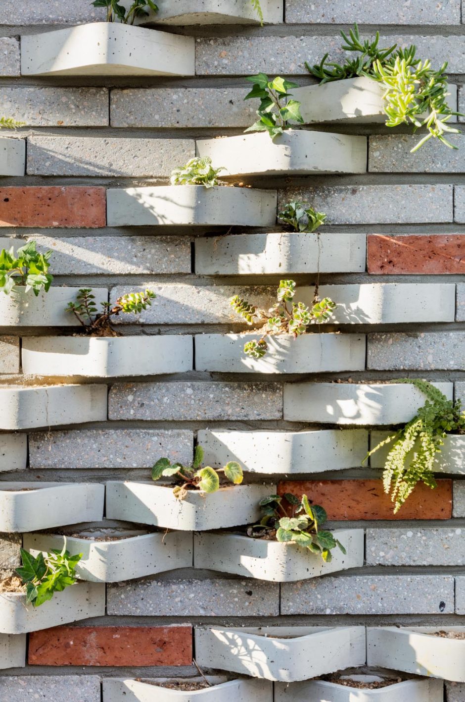 Bricks Designed To Hold Plants Were Used On The Exterior Of This Housing