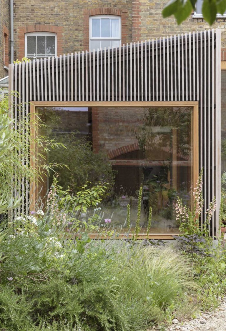 This Home Extension Covered In Vertical Wood Slats Includes A Picture ...