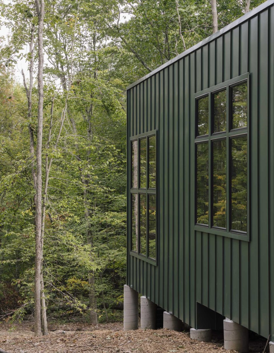 A Green Exterior Helps This Cabin Blend Into The Forest