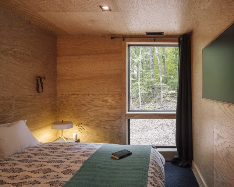 A Green Exterior Helps This Cabin Blend Into The Forest