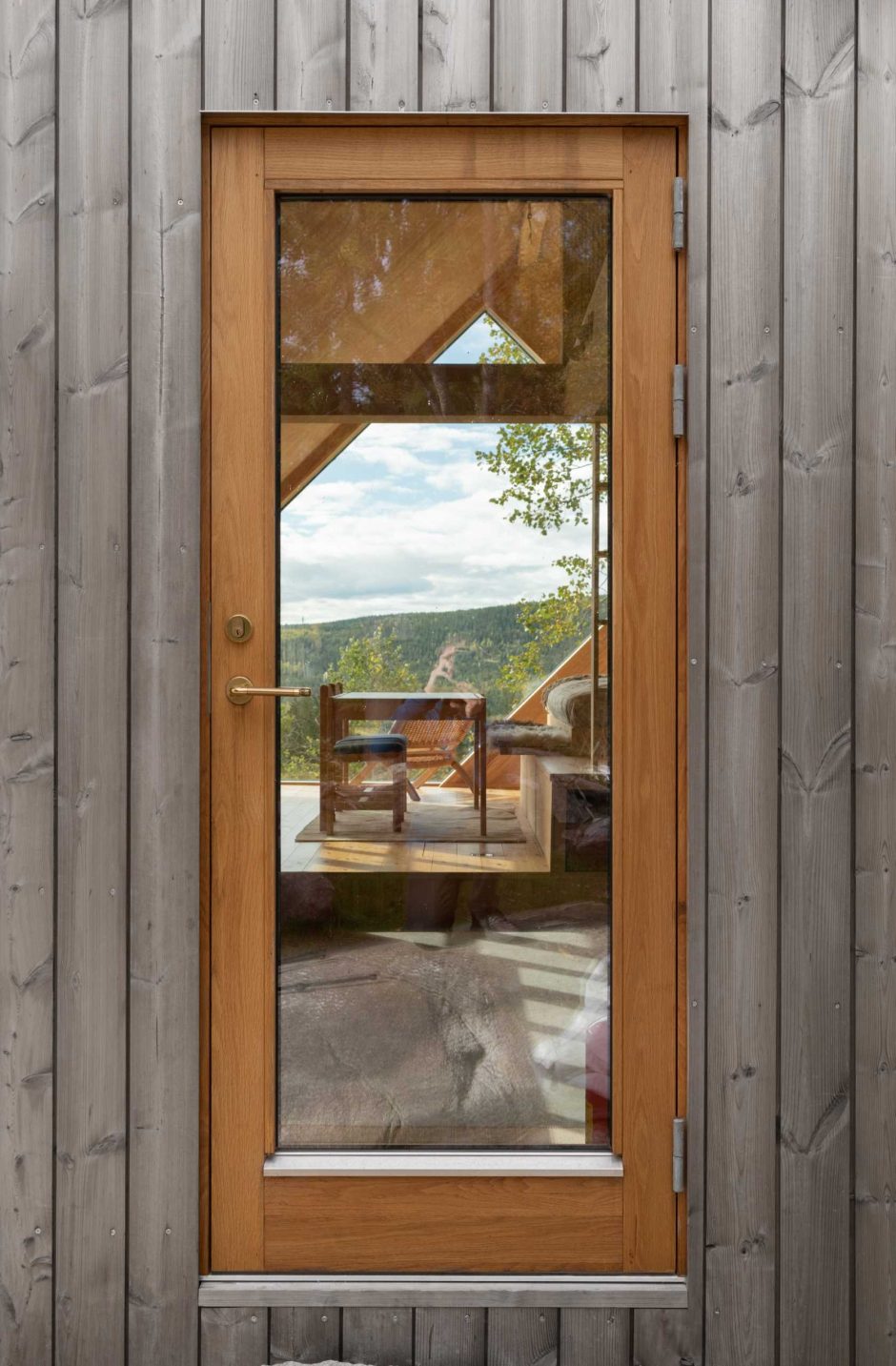 A Unique Window Shape Helps Frame The View From Inside This Cabin
