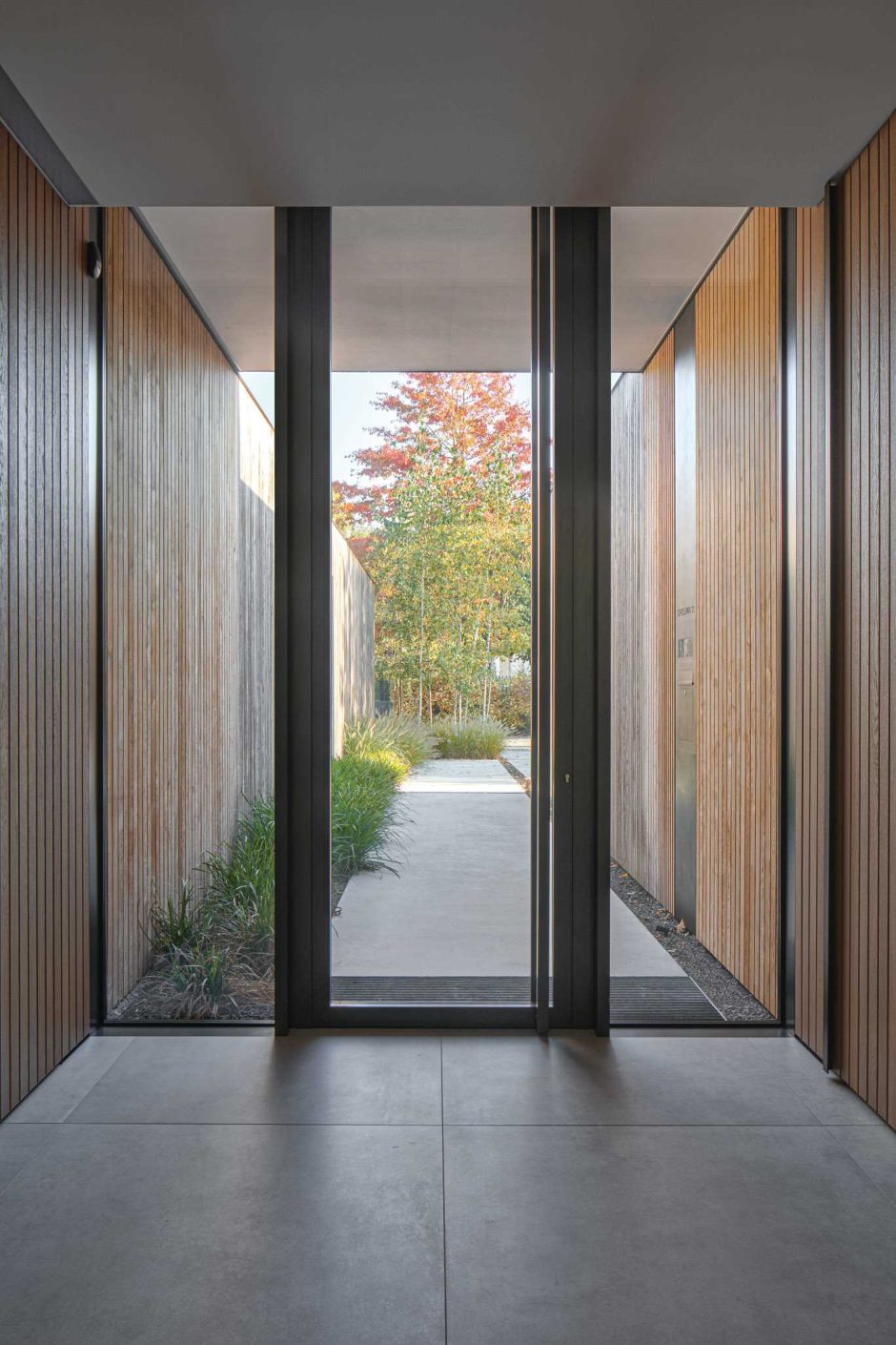 An Exterior Of Vertical Wood Siding Helps This House Blend Into The ...