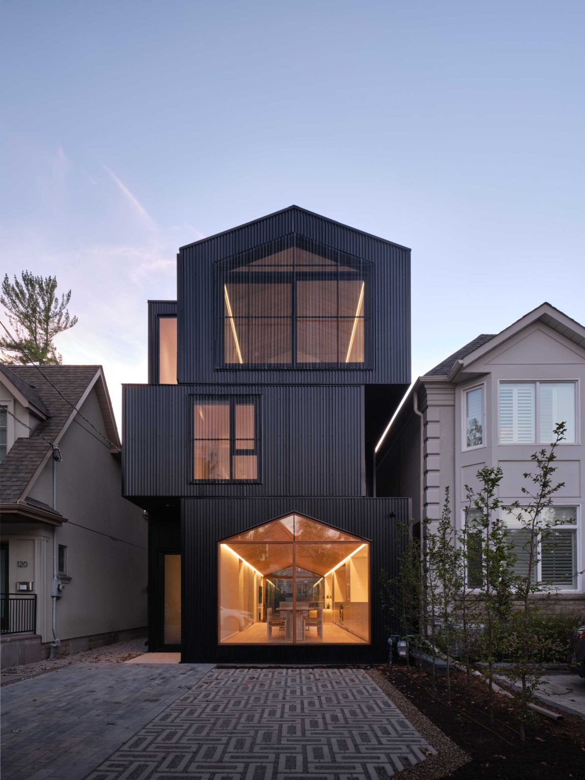 This Tall Black House Appears To Be Made From A Series Of Stacked Boxes