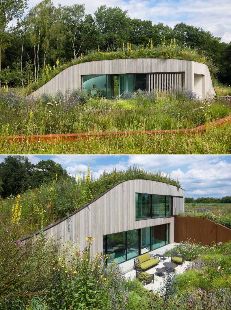 A House Built Into The Ground And Covered In Flowers