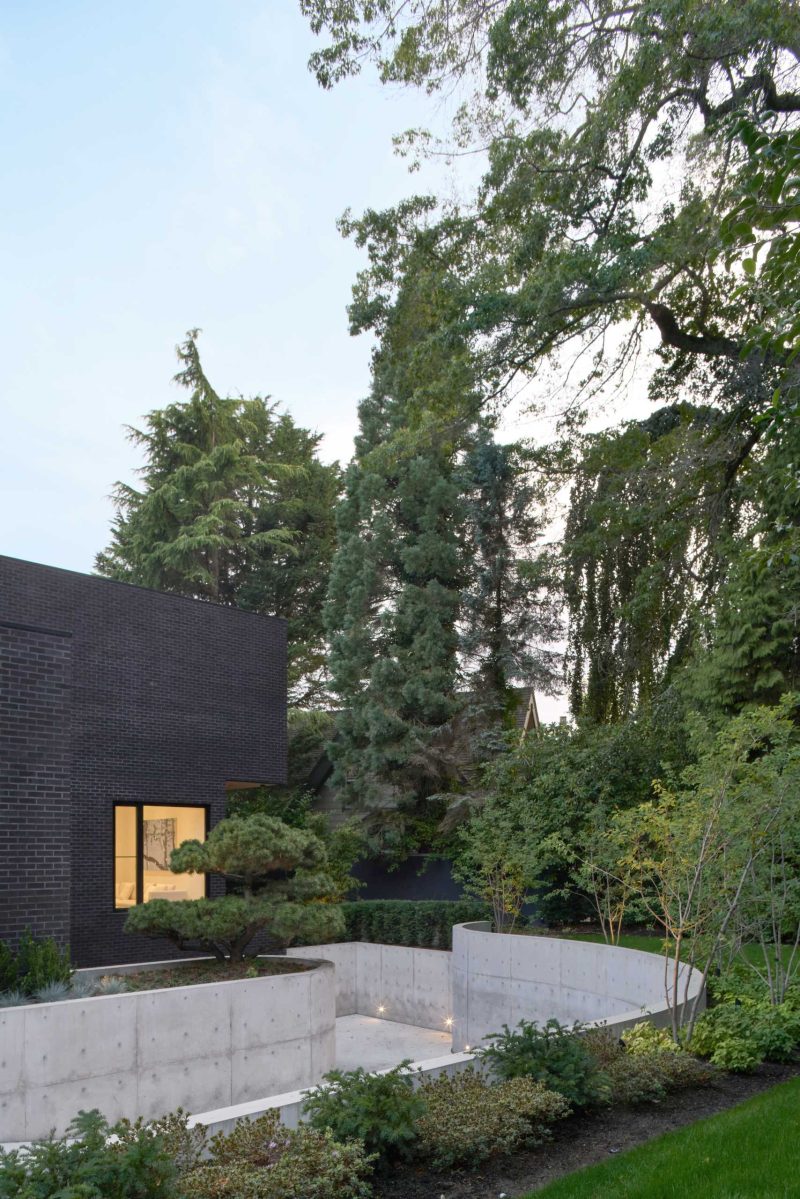 A Dark Brick Exterior For A Home Surrounded By Trees | ARCHCOD