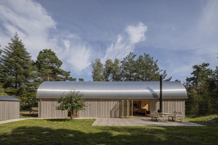 A Tube-Shaped Danish Summer Home With a Curved Corrugated Roof