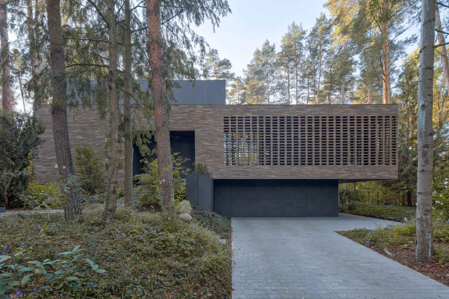 Curved Glass and Brick Define This Forest House